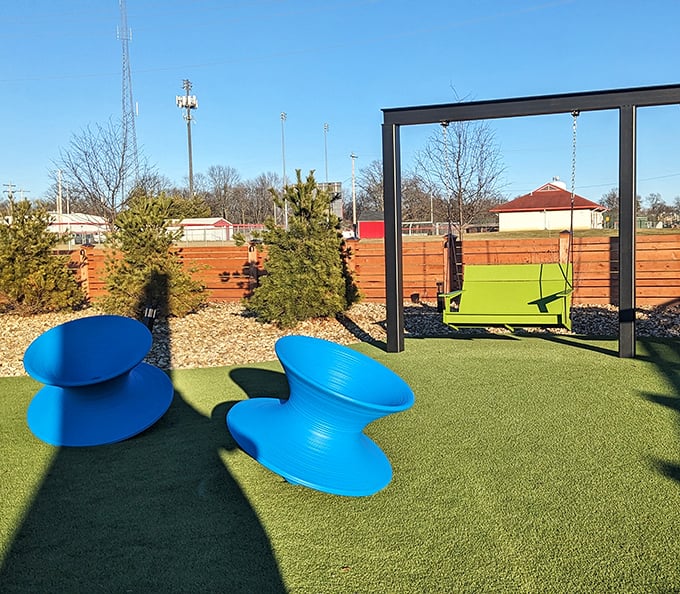 Outdoor seating that's part playground, part lounge area. Those blue chairs look like they fell from a modern art museum—in the best way.