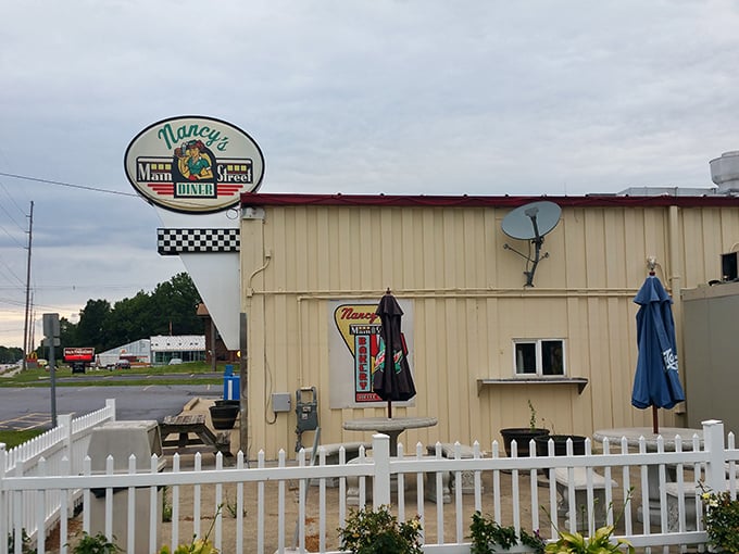 Beyond the white picket fence, Nancy's sign promises roadside salvation for hungry travelers—a beacon of hope when fast food just won't cut it.