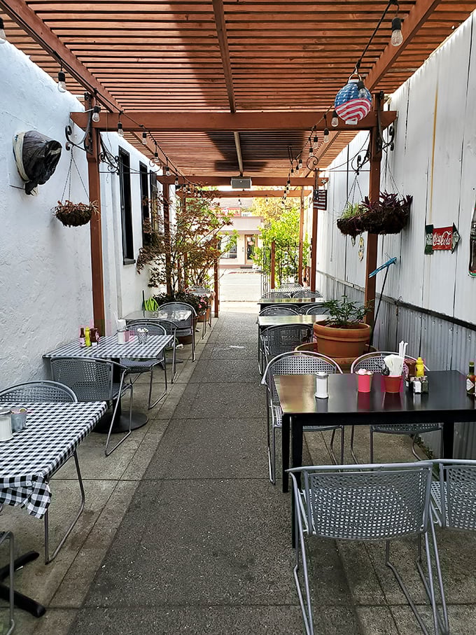 The outdoor seating area offers a peaceful retreat with checkered tablecloths that remind you this is serious comfort food territory.