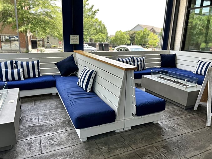 The outdoor patio seating area feels like a private yacht club, minus the membership fees. Navy cushions and striped pillows complete the nautical fantasy.