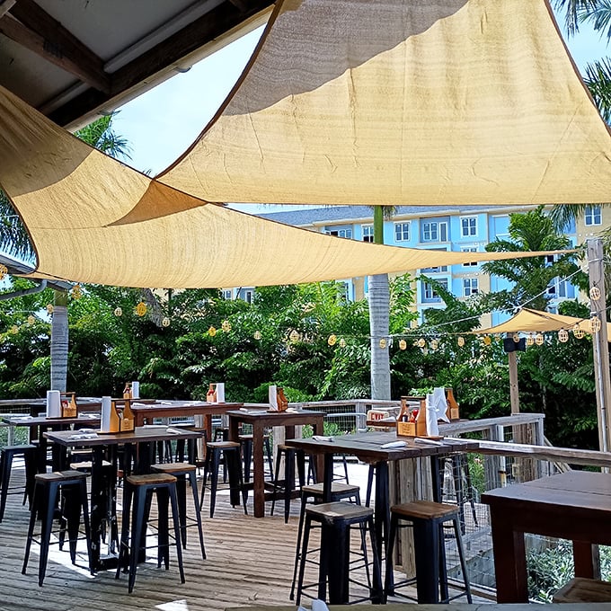 Canvas sails provide just enough shade without blocking the breeze—proof that sometimes the best dining innovations are thousands of years old.