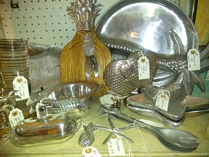 Pineapple-shaped serving pieces and silver platters waiting for their second act. These aren't just utensils—they're conversation pieces with handles.