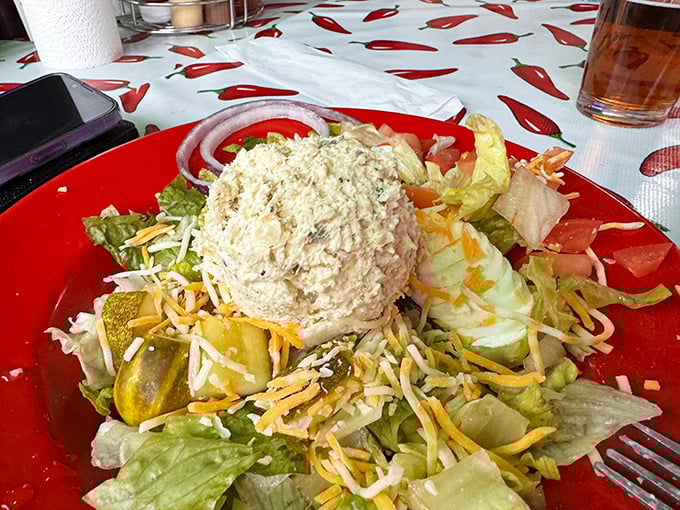 This chicken salad doesn't just sit on lettuce—it commands the plate like a general. The pickle stands guard against any vegetable rebellion. 