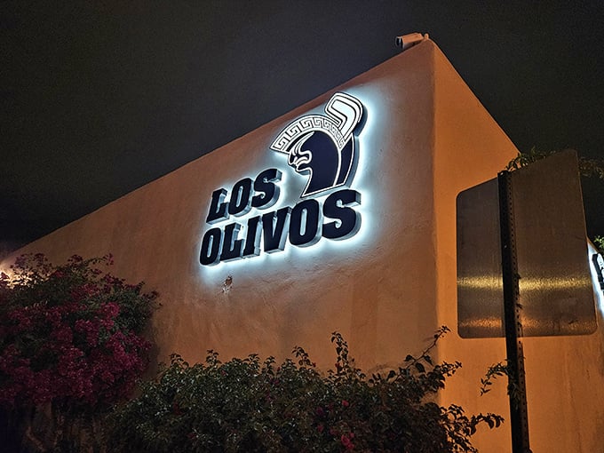 The Los Olivos sign glows like a beacon in the night, guiding hungry travelers to their queso-covered destiny.