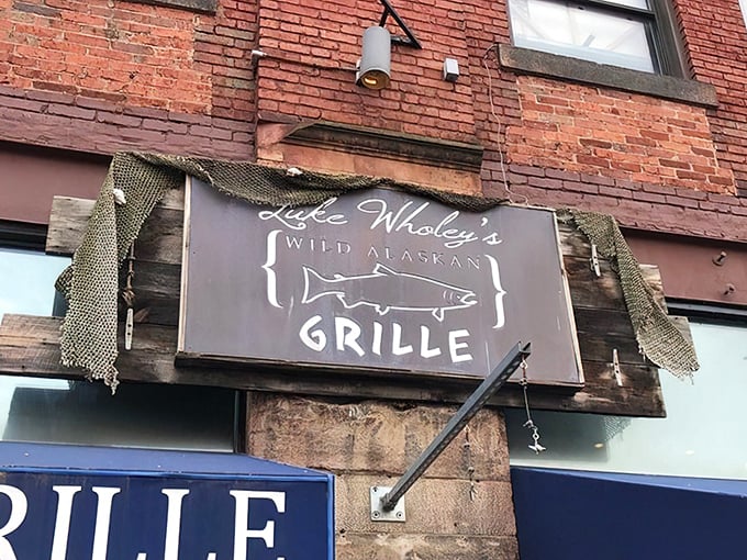 The rustic wooden sign with fishing net trim tells you everything you need to know—this place takes seafood seriously, with a playful wink.
