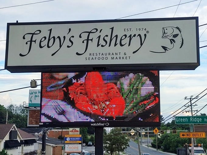 The roadside sign glows like a beacon for hungry travelers—a digital lighthouse promising safe harbor for seafood cravings.