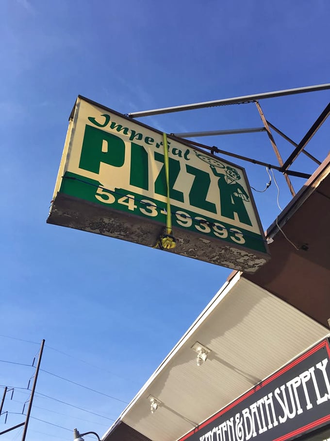 The iconic green and white Imperial Pizza sign has guided hungry travelers like a lighthouse beacon for generations of pizza pilgrims.