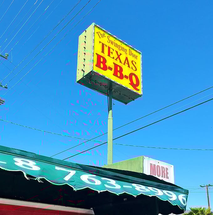 That yellow and red sign against the blue California sky—a Texas BBQ promise standing tall in North Hollywood.