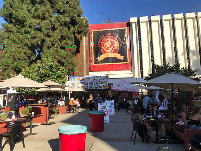 The food court area offers respite for weary shoppers, where Fairfax High School's banner reminds you that your purchases support education.