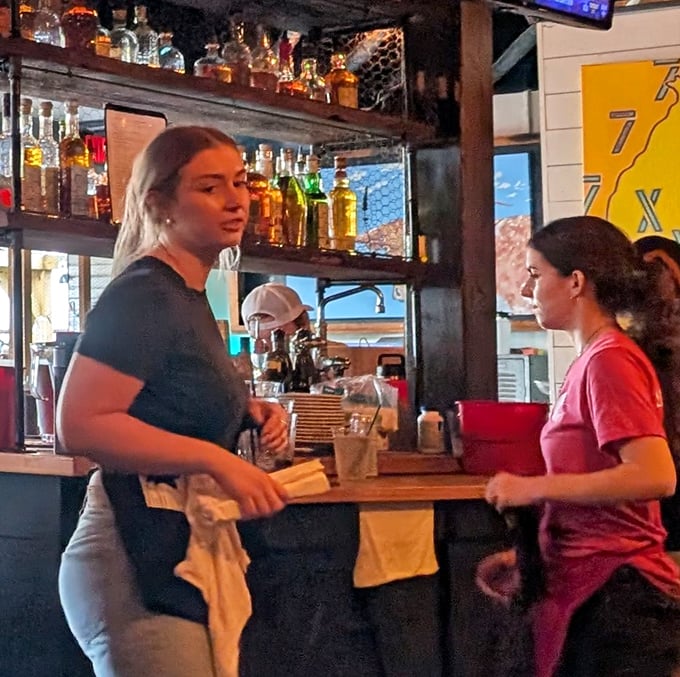 The image shows staff members at work in the restaurant environment.