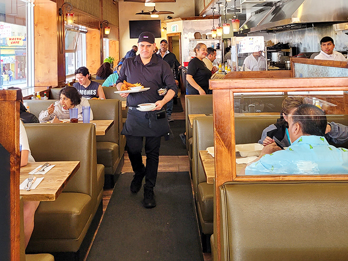 The server dance—navigating narrow aisles with plates balanced like circus performers, all while remembering who ordered the extra crispy bacon.
