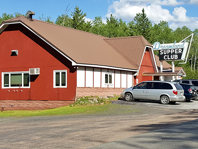 The daytime view reveals Dreamland's barn-red exterior—standing proud against the northwoods backdrop like a beacon for hungry travelers.