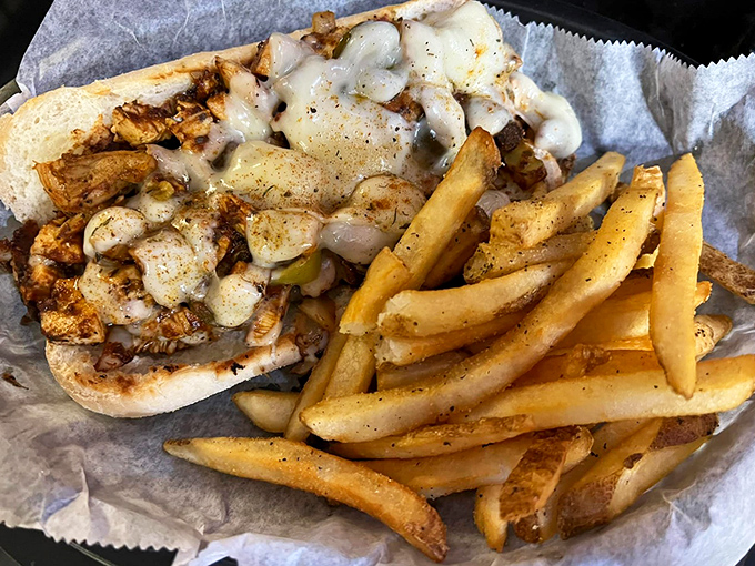 Blackened chicken meets melted cheese in a sandwich that makes you wonder if you should take a photo first or just surrender to immediate consumption.