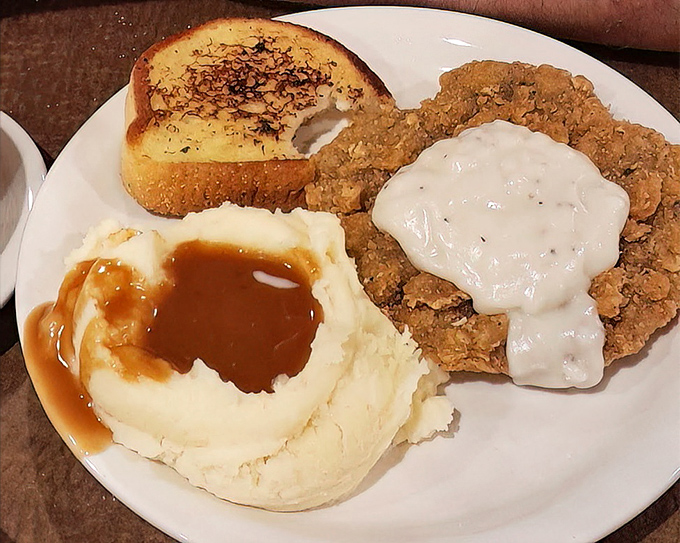 Chicken fried steak with gravy pools in mashed potatoes—a plate that says "you won't need dinner" with the confidence of a heavyweight champion.