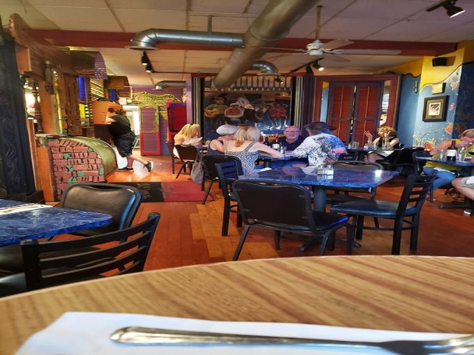 The vibrant dining area buzzes with conversation and clinking glasses—proof that great seafood creates community, even hundreds of miles from any ocean.