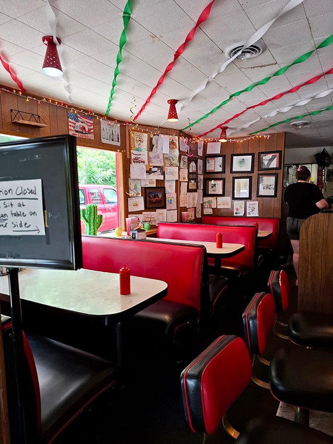 The wall of memories tells stories of satisfied customers past, while red booths stand ready to host the next chapter of your personal burger journey.