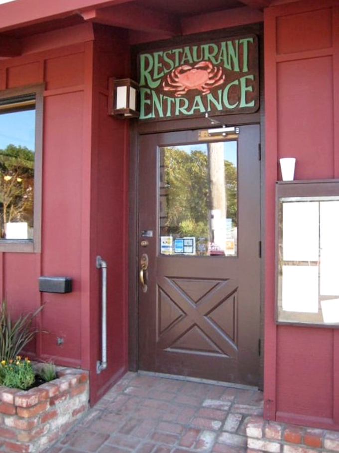 The entrance sign featuring a crab announces exactly what you're in for—coastal comfort that's been perfected since long before "farm-to-table" was trendy.