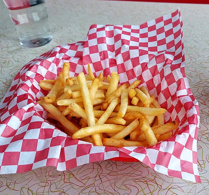 French fries served in checkered paper—a humble presentation for what might be the perfect supporting actor in the burger show.