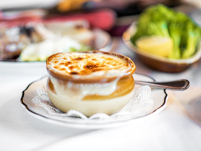 French Onion Soup with a golden crown of bubbling cheese that stretches with each spoonful. This isn't just soup—it's a warm hug in a crock.
