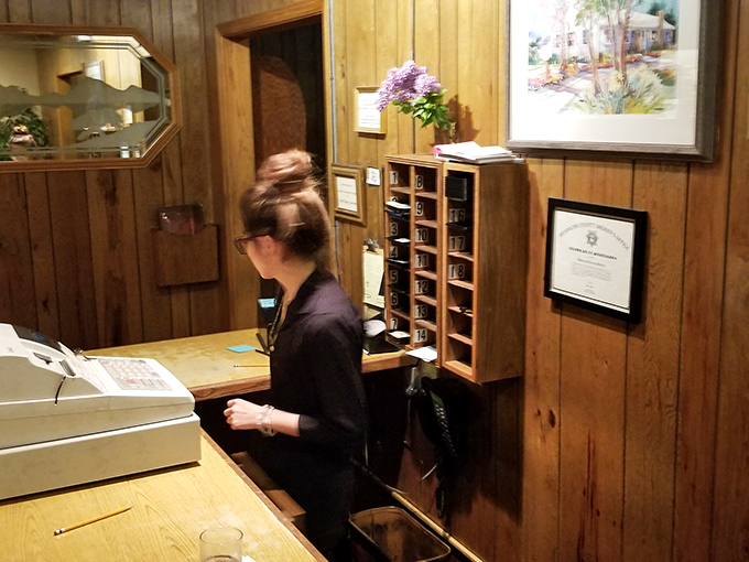 The host station—gateway to happiness, where they don't just take your name, they prepare to make you temporarily forget all your problems. 