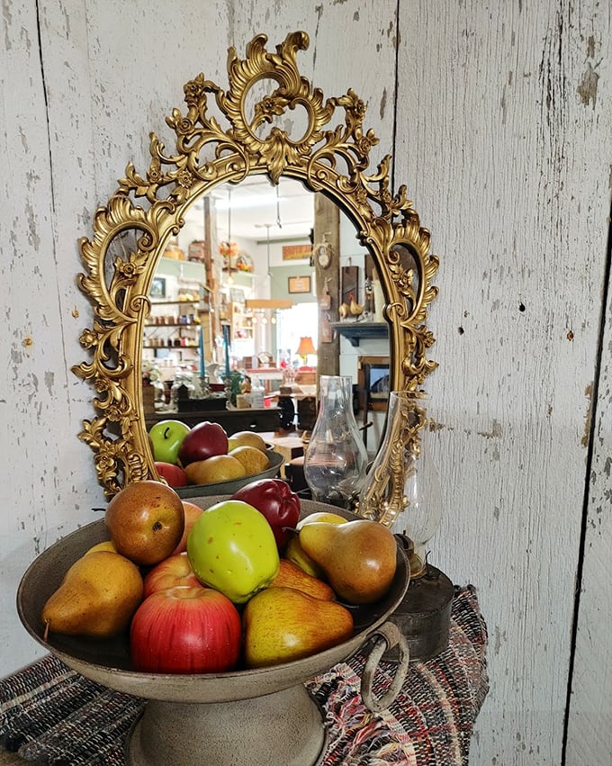 This ornate gold mirror doesn't compete with the simple fruit bowl—they're having a conversation about contrast that's been going on for centuries.