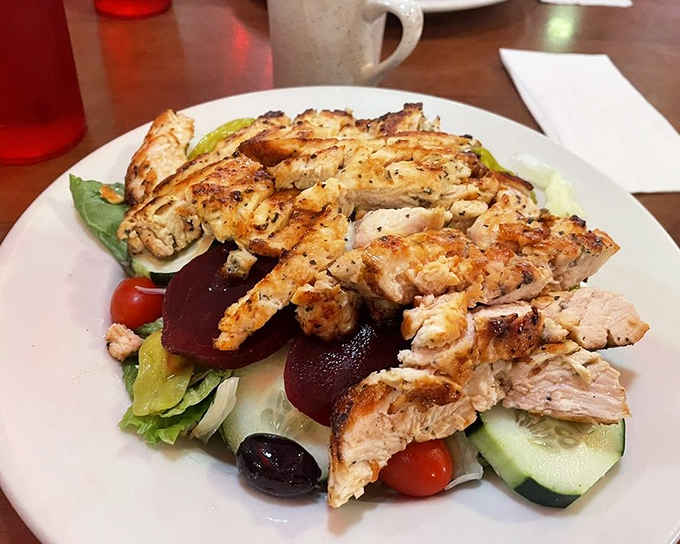 A Greek salad topped with grilled chicken that makes eating healthy feel like cheating. Those olives are plotting something delicious.