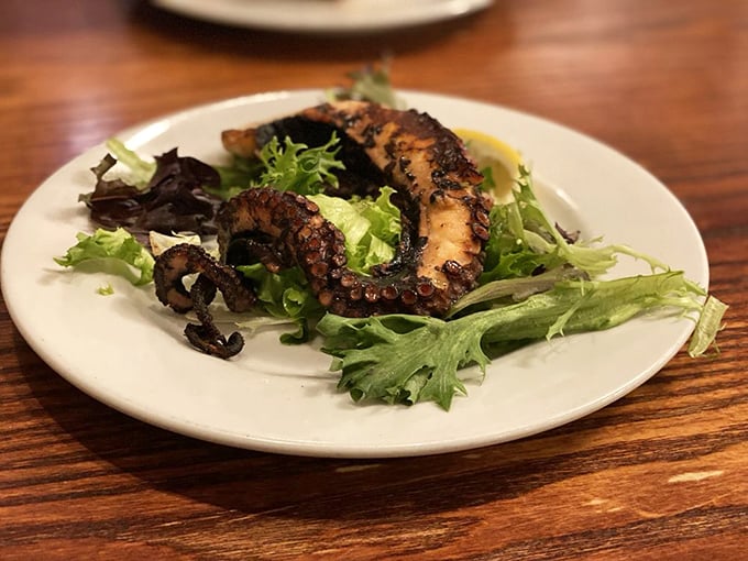 Grilled octopus: the ultimate test of a Greek kitchen's prowess. Perfectly charred tentacles rest on fresh greens—simple, authentic, and utterly magnificent.