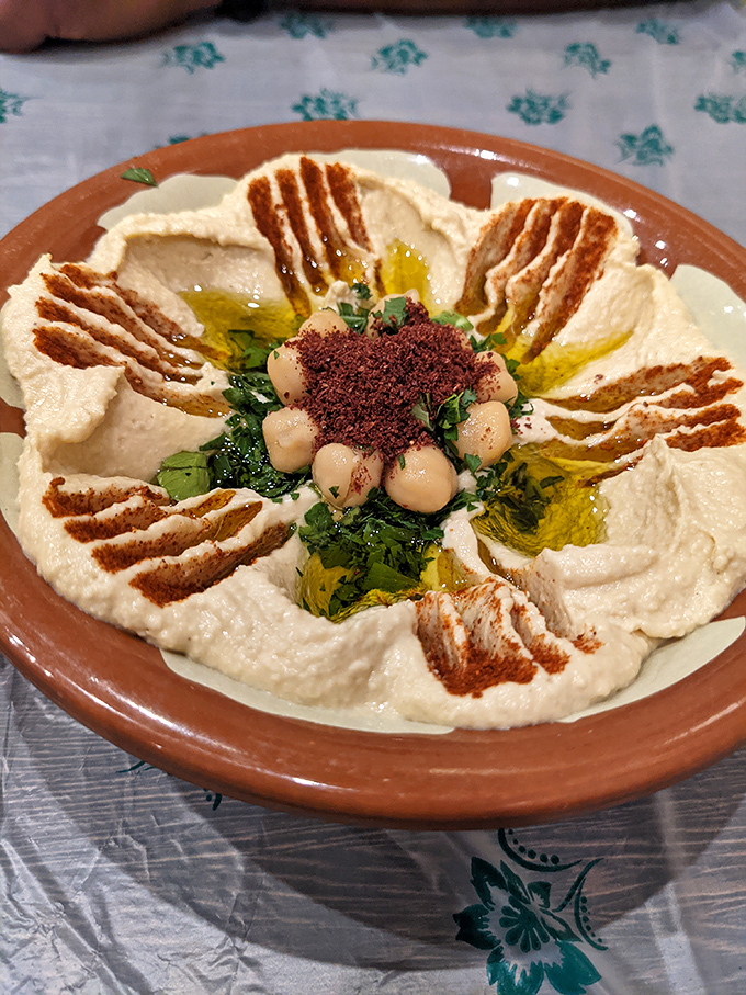 Hummus elevated to art form – a canvas of creamy perfection adorned with olive oil rivers and spice islands. Proof that simplicity can be spectacular.