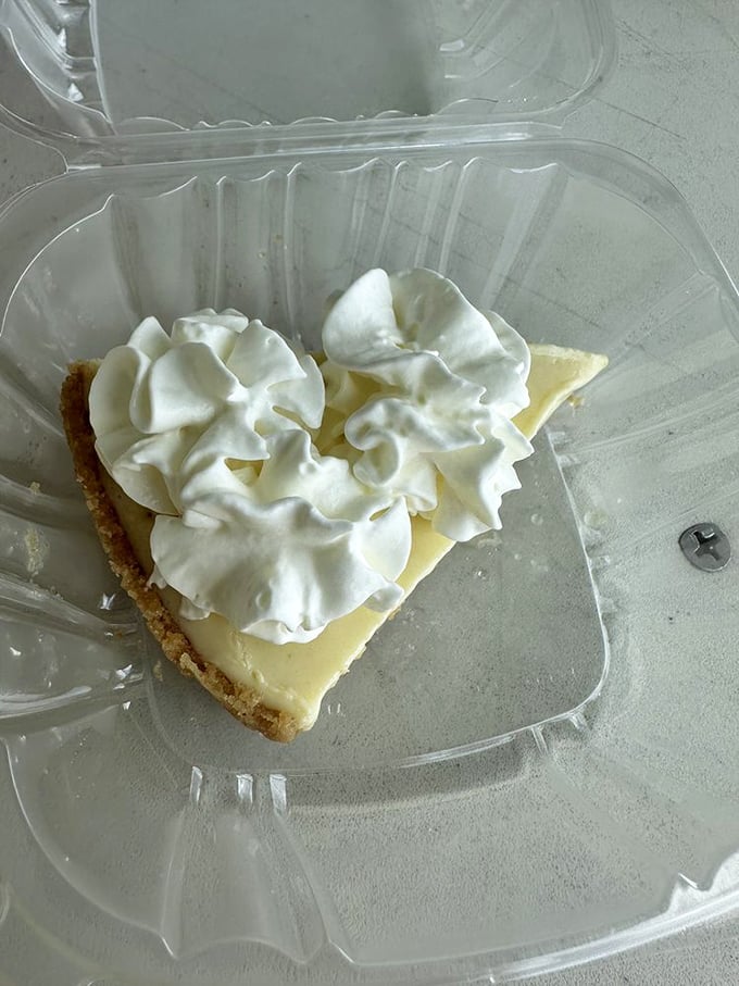 Key lime pie slice topped with clouds of whipped cream, ending meals on heavenly notes.