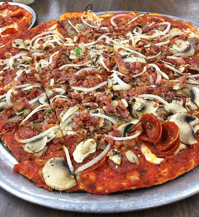 The supreme pizza—where every topping fights for your attention like siblings vying for the front seat, yet somehow creates perfect harmony in each bite.