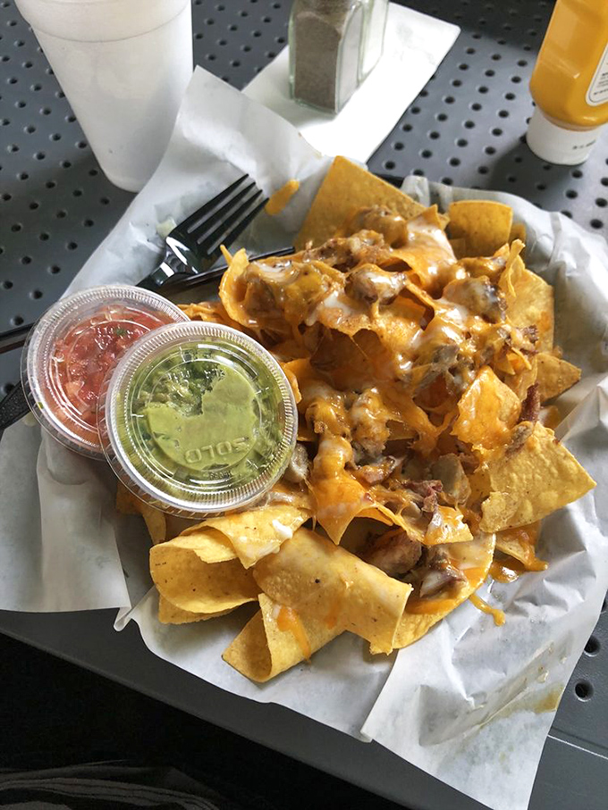 Loaded nachos that require a strategy to eat. Each chip a delivery vehicle for melted cheese, meat, and those precious cups of salsa and guacamole.