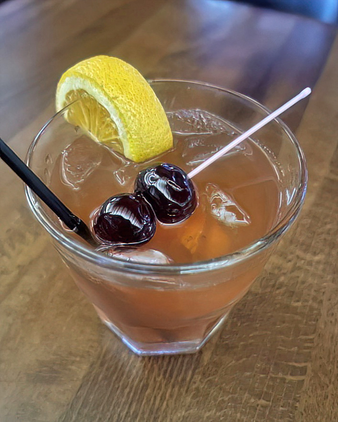 An Old Fashioned that looks like it was mixed by someone who respects tradition. Those cherries have soaked up just enough whiskey to make dessert unnecessary.
