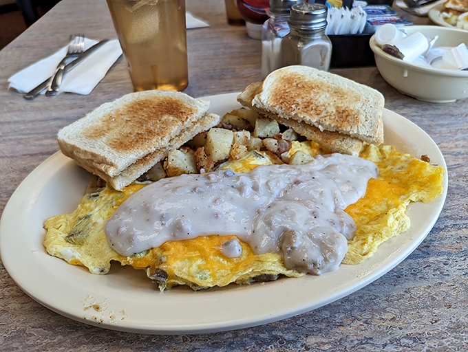 An omelet that's having an identity crisis as biscuits and gravy—and we're all better for it. This plate doesn't just feed you; it adopts you.