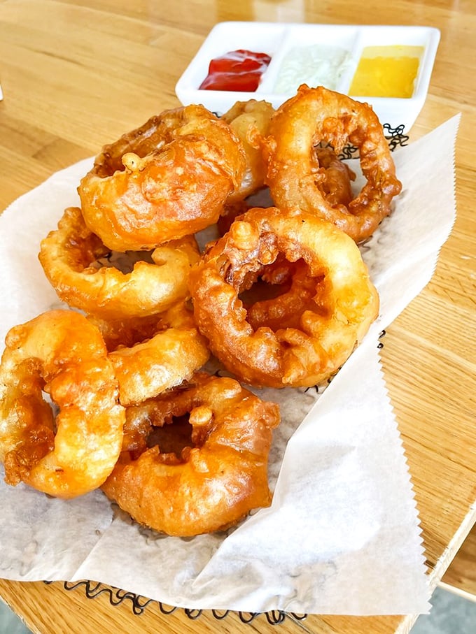 These aren't just onion rings—they're golden halos of crispy perfection, waiting to be dipped in that trio of sauces for flavor enlightenment.