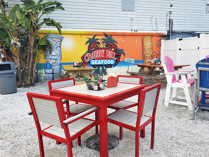 The outdoor patio, with its bright red furniture and tiki-inspired mural, offers a slice of paradise where sandy feet are welcome and seafood is the star.