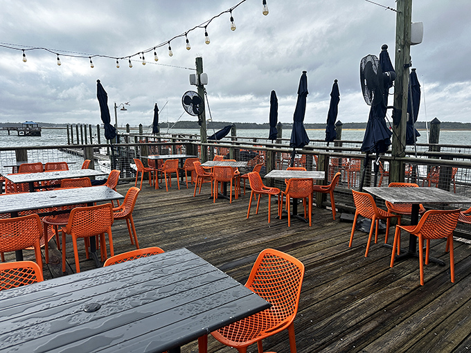 Orange chairs pop against the weathered deck like buoys in the harbor. The perfect perch for seafood feasting with a side of sea breeze.