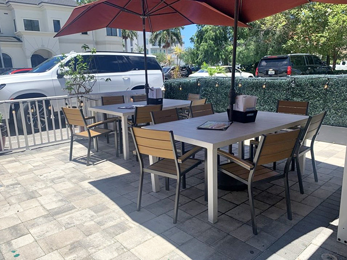 Florida dining at its finest—outdoor tables under umbrellas where the gentle breeze complements your burger experience perfectly.