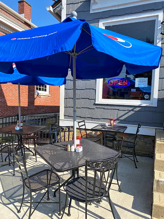 Blue umbrellas shield outdoor tables from the Ohio sun, creating the perfect spot for people-watching with your pancakes.