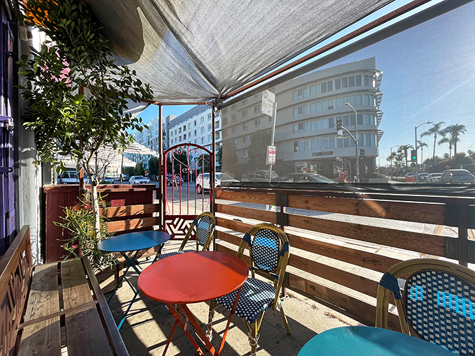 The perfect urban oasis – colorful tables, bistro chairs, and just enough greenery to make your breakfast feel like a mini vacation.