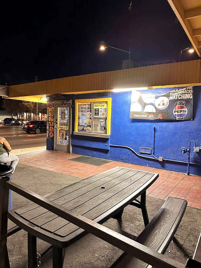 As night falls, the blue building glows like a beacon for those seeking burrito salvation. Some treasures are best discovered after dark.
