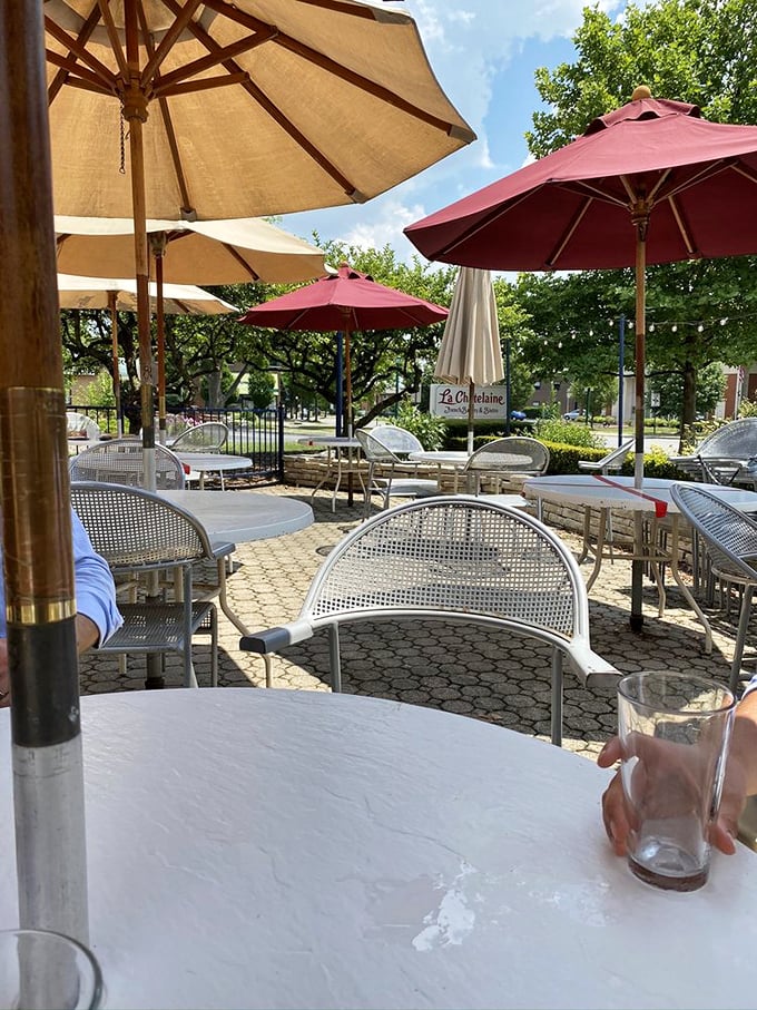 Red umbrellas standing guard over tables where memories are made—one croissant, conversation, and coffee at a time.