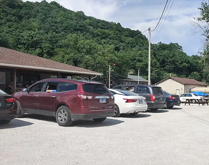 A parking lot full of vehicles with one thing in common – drivers who know that the best food often hides in the most unassuming places.