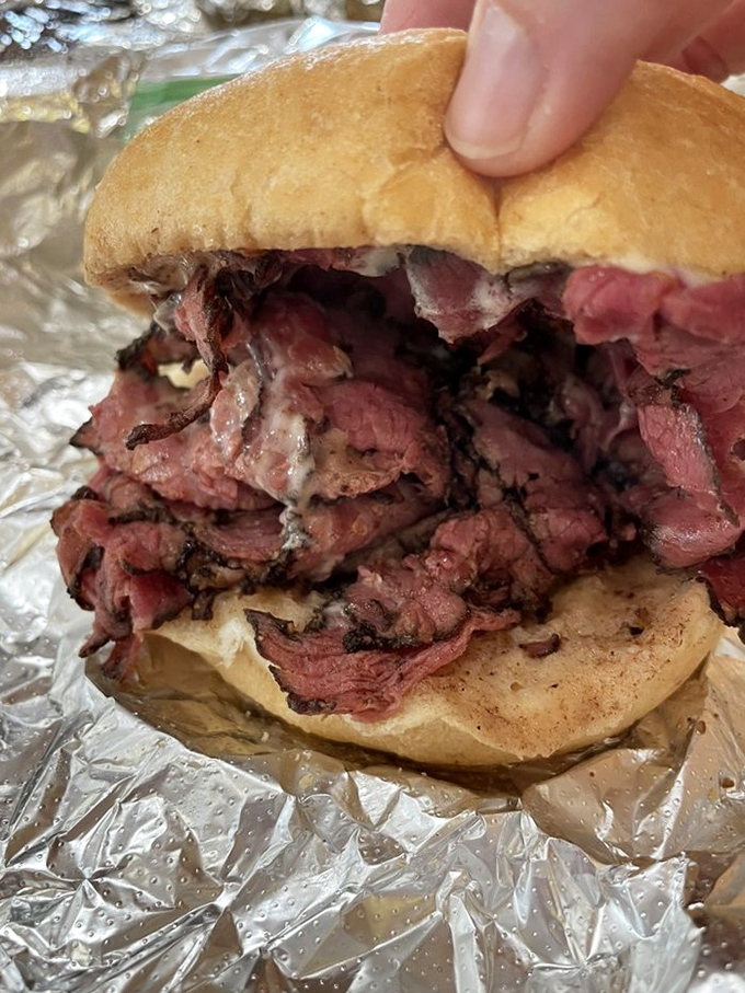 The pastrami and cheese sandwich in its natural habitat—aluminum foil, ready to be devoured by someone who knows that simplicity often trumps complexity.