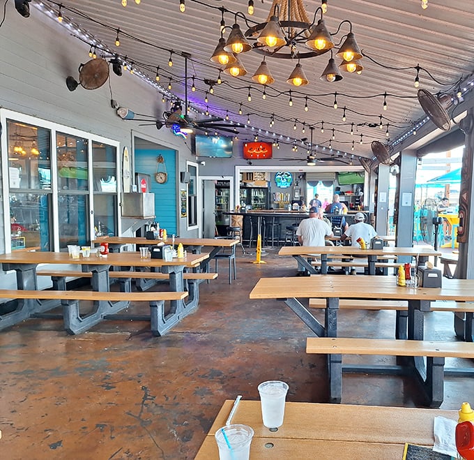 Picnic tables under string lights create the perfect casual vibe. This covered patio says "stay awhile" in a way fancy restaurants never could.
