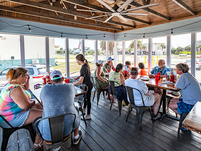 The screened porch dining area—where the Gulf breeze meets your feast. Nothing enhances seafood like actual sea air.