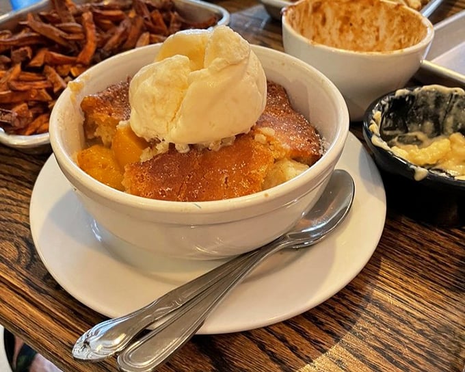 Peach cobbler that makes you want to write poetry. That scoop of vanilla ice cream isn't melting—it's swooning over its sweet companion.
