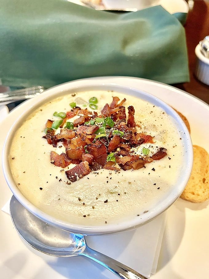 Velvety potato soup crowned with crispy bacon bits and green onions – proof that simple ingredients become extraordinary in the right hands.