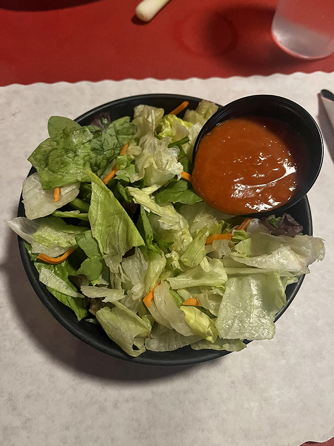 Even the side salad gets respect here – a crisp, fresh counterpoint to the richness that follows, proving that balance exists in all great meals.