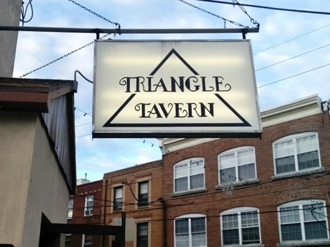 The illuminated Triangle Tavern sign hangs like a beacon for hungry travelers, promising good food and better company within.