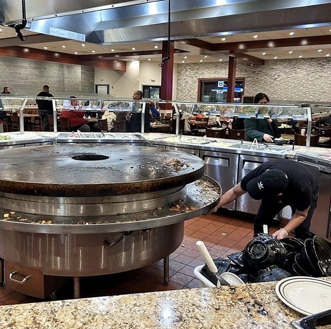 Where the magic happens – staff tending to the cooking stations ensure fresh offerings throughout your dining experience.